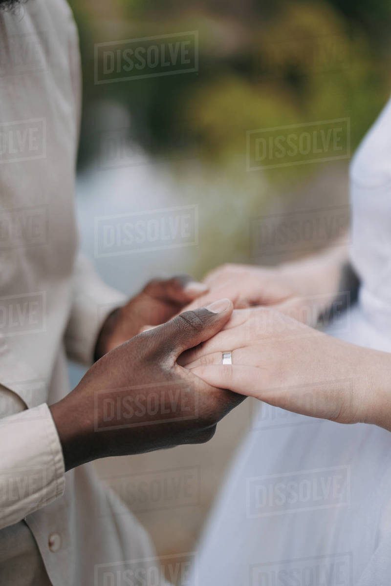 Interracial couple newlyweds holds each other hands. Close-up. Concept ...