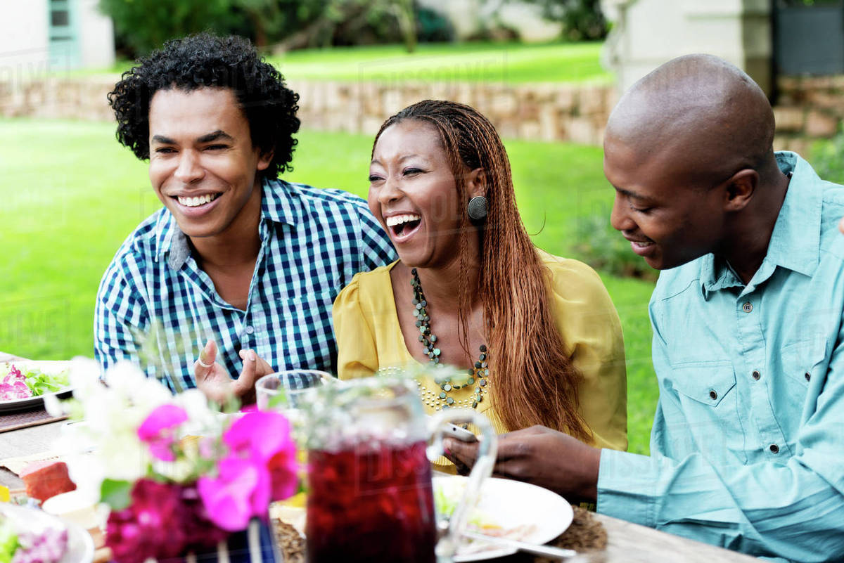 Friends laughing at the lunch table - Stock Photo - Dissolve