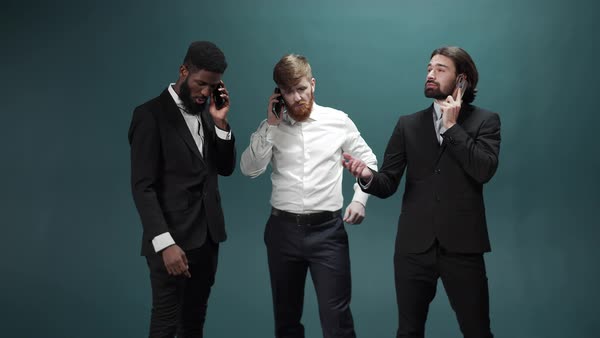 Three men friends in tuxedos are standing together and talking to the ...