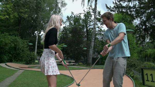 Man and women sword fighting with golf clubs slow motion. Wide shot of ...