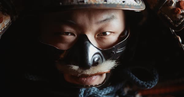 Japanese man in traditional samurai armor and authentic helmet looking ...