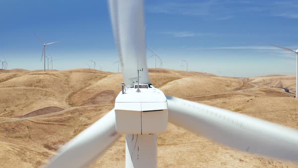 Aerial. 4K. Close aerial shooting of a spinning windmill, one of many ...