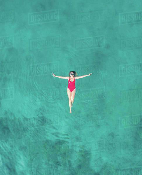 Aerial View of a Woman in Red Swimsuit Floating Serenely on the Crystal ...