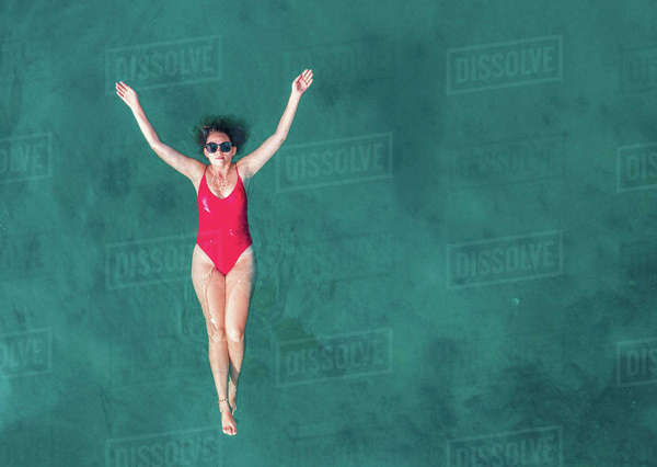 Aerial View of a Woman in Red Swimsuit Floating Serenely on the Crystal ...