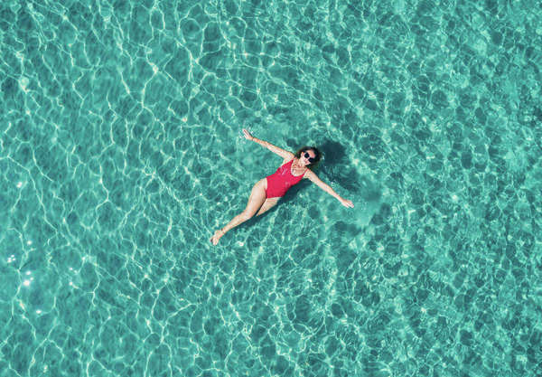 Aerial View of a Woman in Red Swimsuit Floating Serenely on the Crystal ...