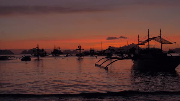 Gimbal steadycam shot of traditional philippine boats bangka at sunset ...