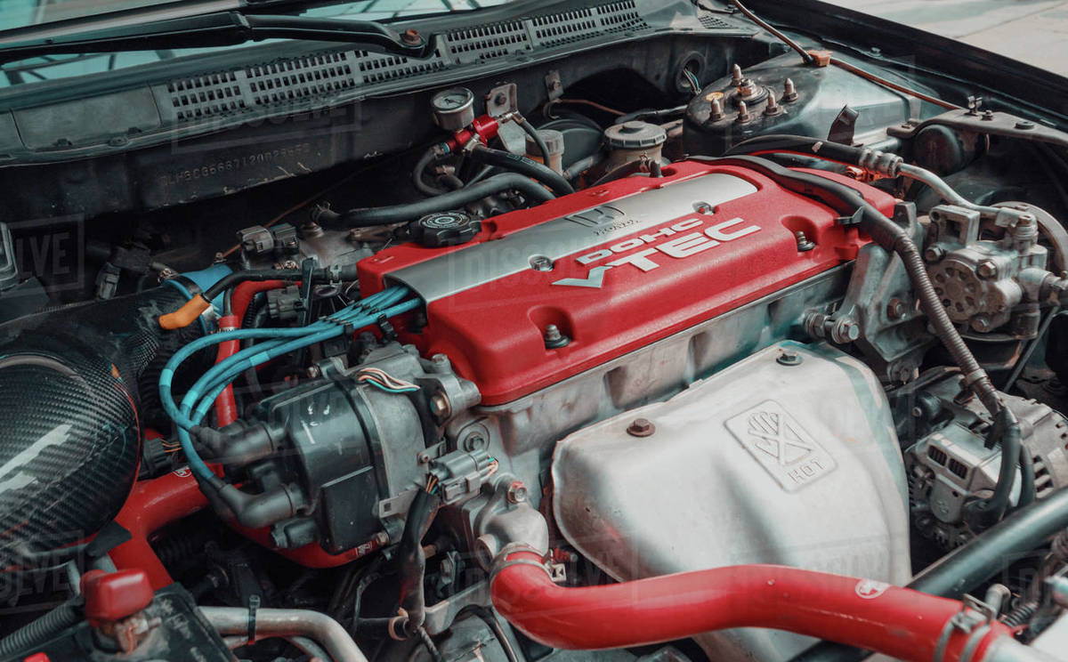 The engine bay of a Honda car, showing a modified engine with a red ...