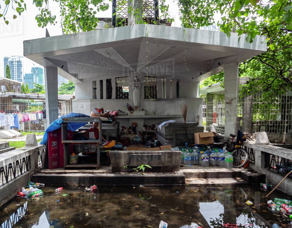 A homeless individual lives on a tomb on a cemetery in Manila amid ...