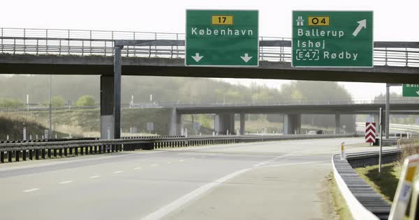Wide shot of road signs on railing over highway - Stock Video Footage ...