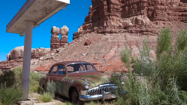 An old car sits at am abandoned gas station along a rural highway in ...