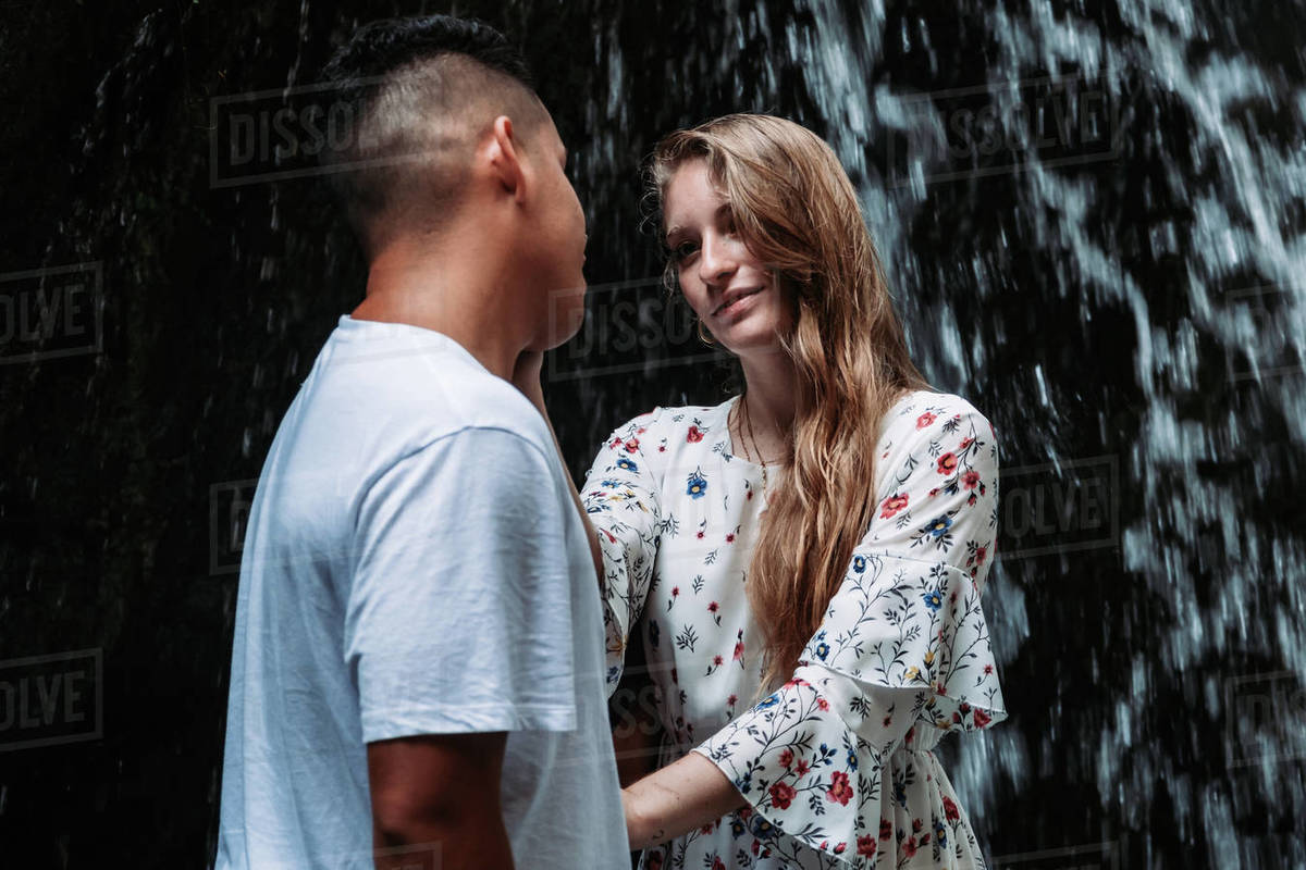 Enamored young couple standing with a beautiful nature scene behind ...