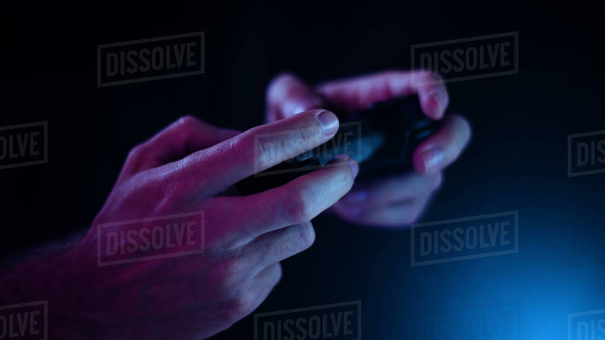 Playing video games close up with a black background - Stock Photo ...