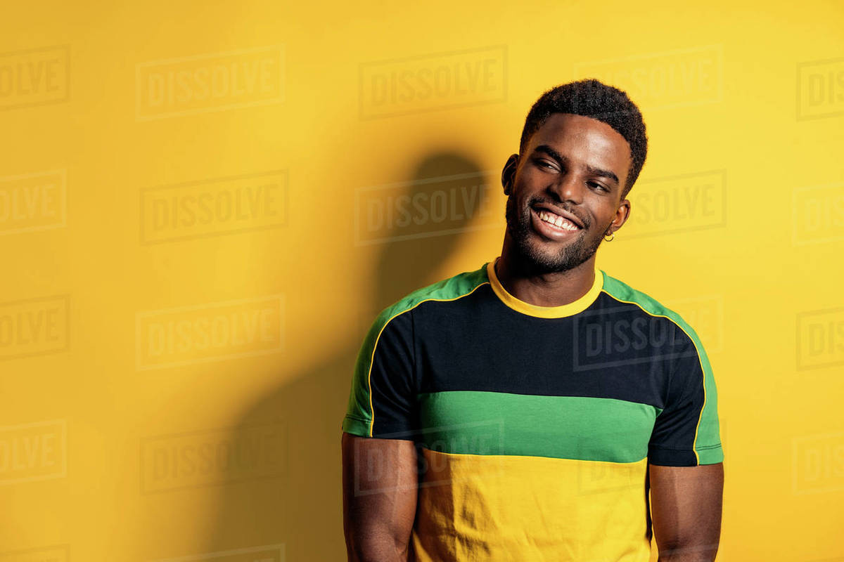 Portrait of young african man on bright yellow background - Royalty ...