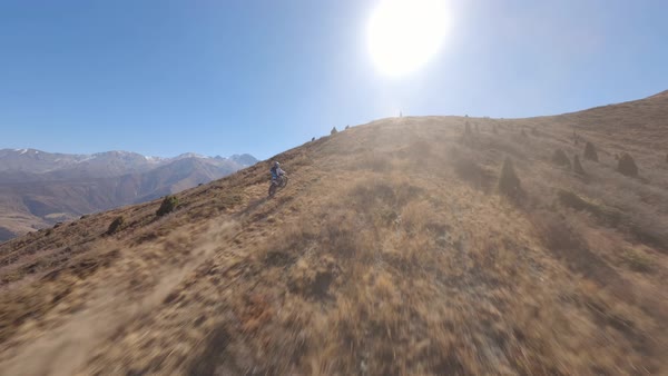 Uphill speed race mountain dirt motorbike man rides past a standing ...