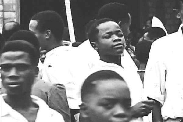 Churchgoers hug each other and shake hands and smile on church grounds ...