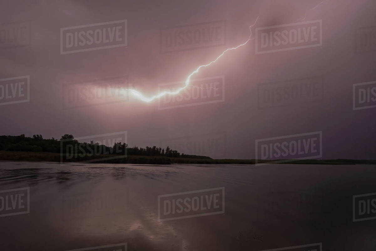 The lightning is real. Thunderstorm at night on the lake. The lightning ...
