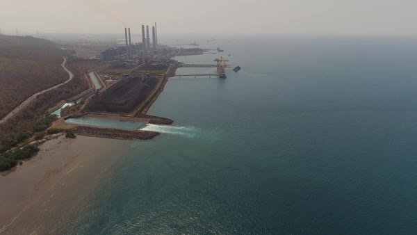 Power station with spillway by sea with smoking pipes, paiton java ...