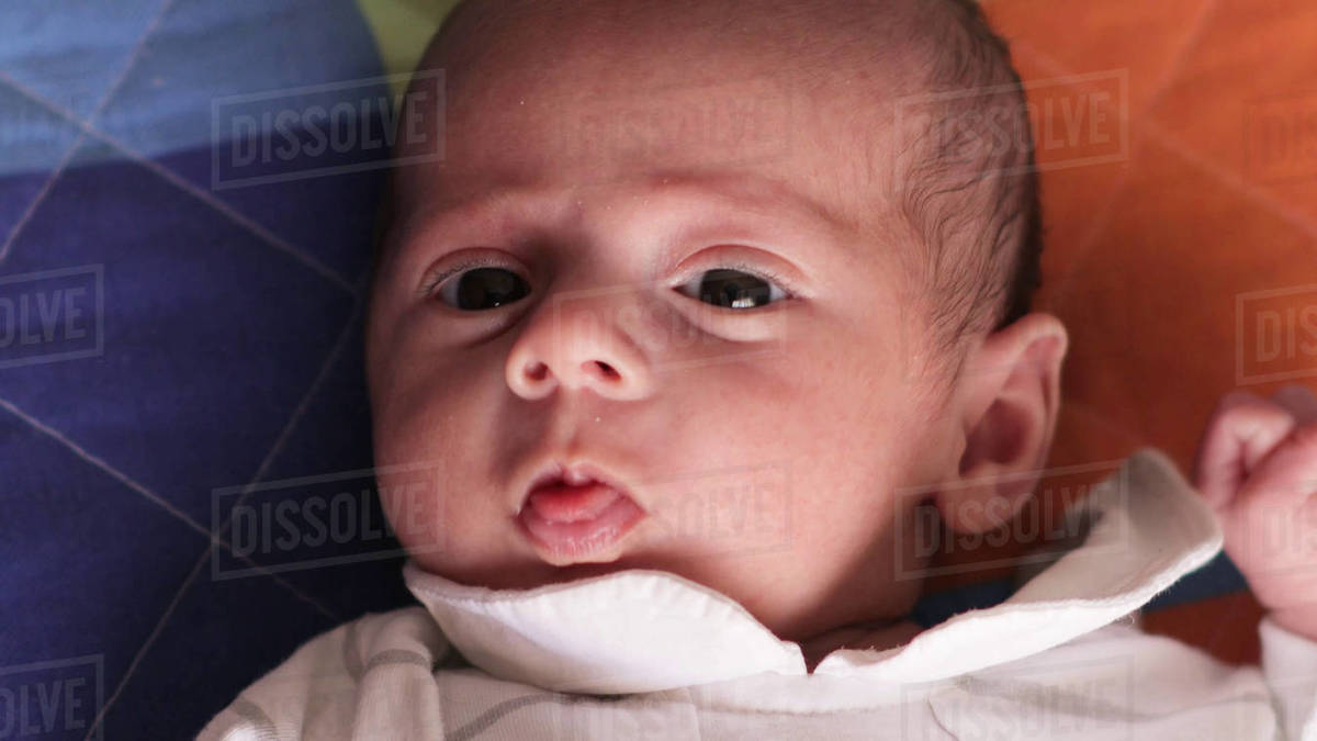 Close up view of a little baby crying while lying on bed. - Stock Photo ...