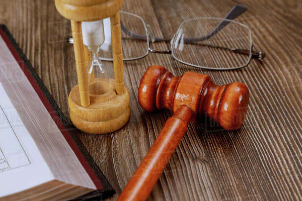 Open Holy Bible Book with hourglass judge's gavel on wooden background ...