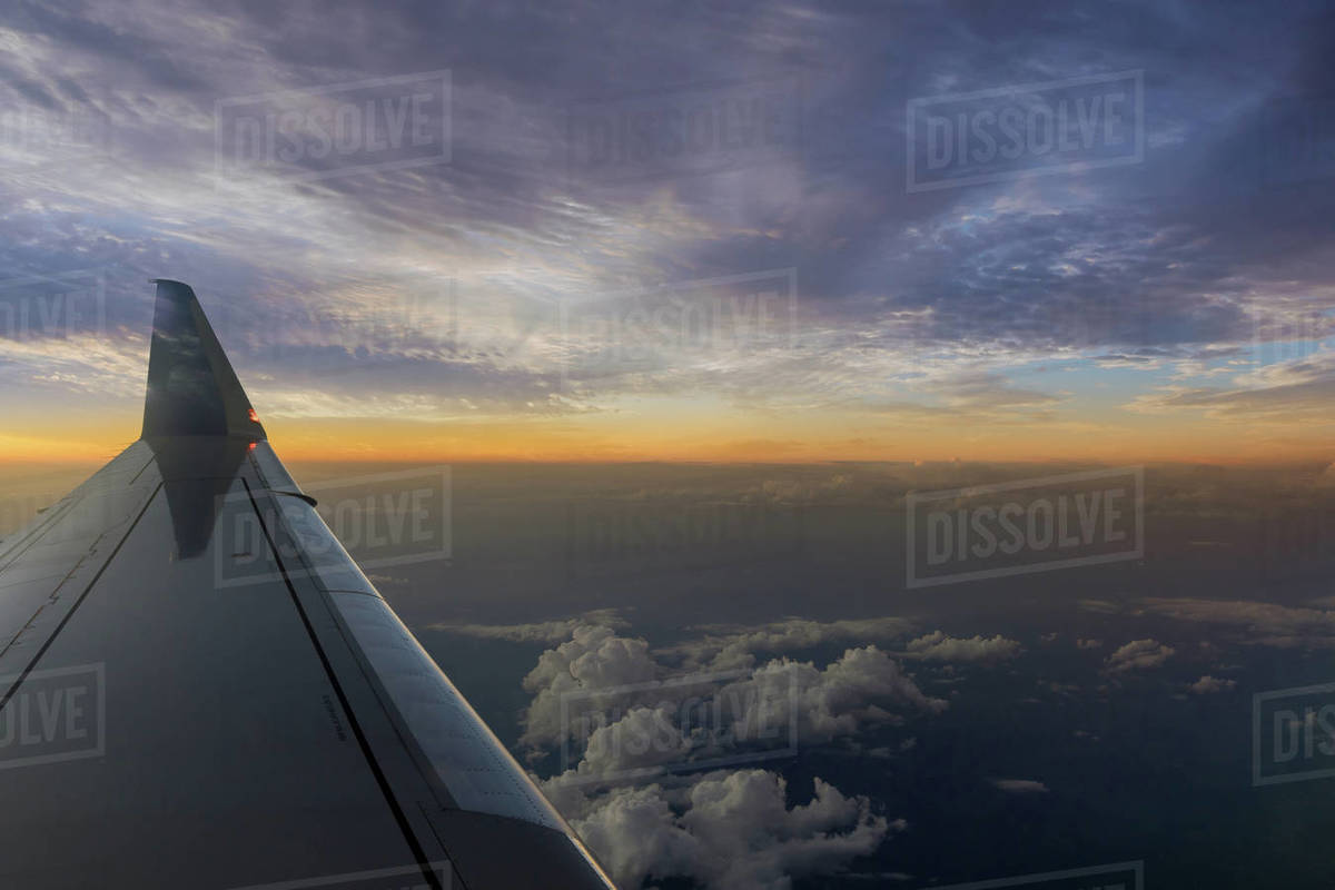 Airplane wing during flight at a wonderful sunset in fluffy clouds - Royalty-free Stock Photo ...