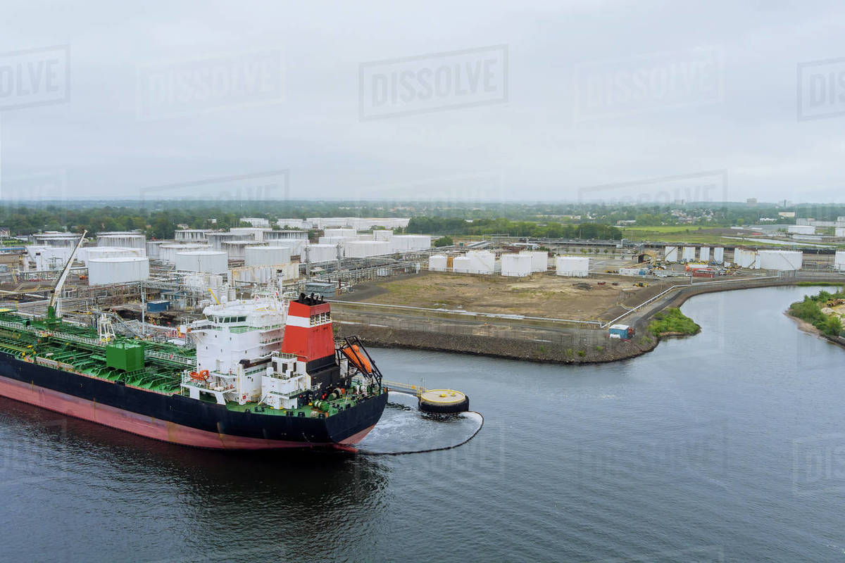 Aerial view oil tanker ship unloading oil storage at industrial dock ...