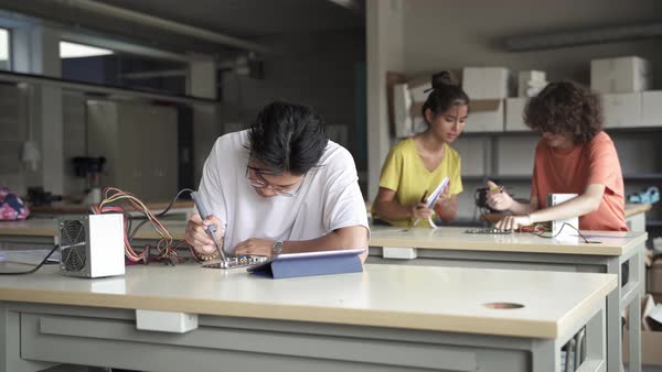 Asian Student soldering electronics circuit board in the science ...