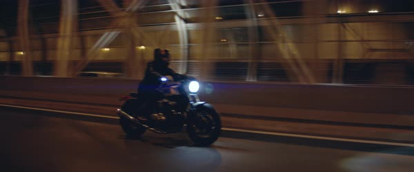 TRACKING Shot of a biker riding his custom built cafe racer motorcycle ...