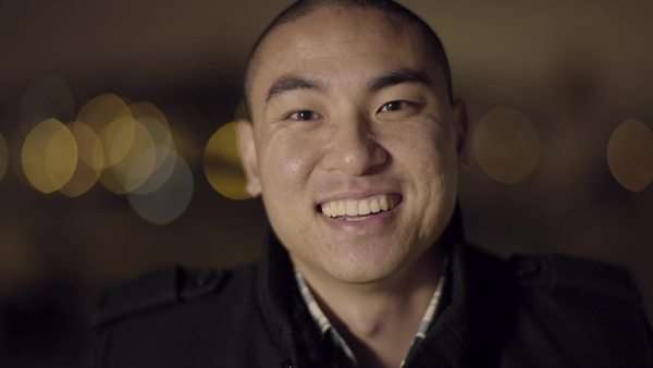 Portrait of happy man smiling on a rooftop in San Francisco at night ...