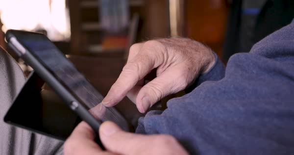 Elderly man scrolling and surfing the internet or using an app on a ...
