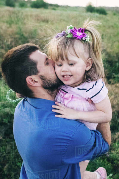 Dad and daughter play together on the flower field. Happy and caring ...