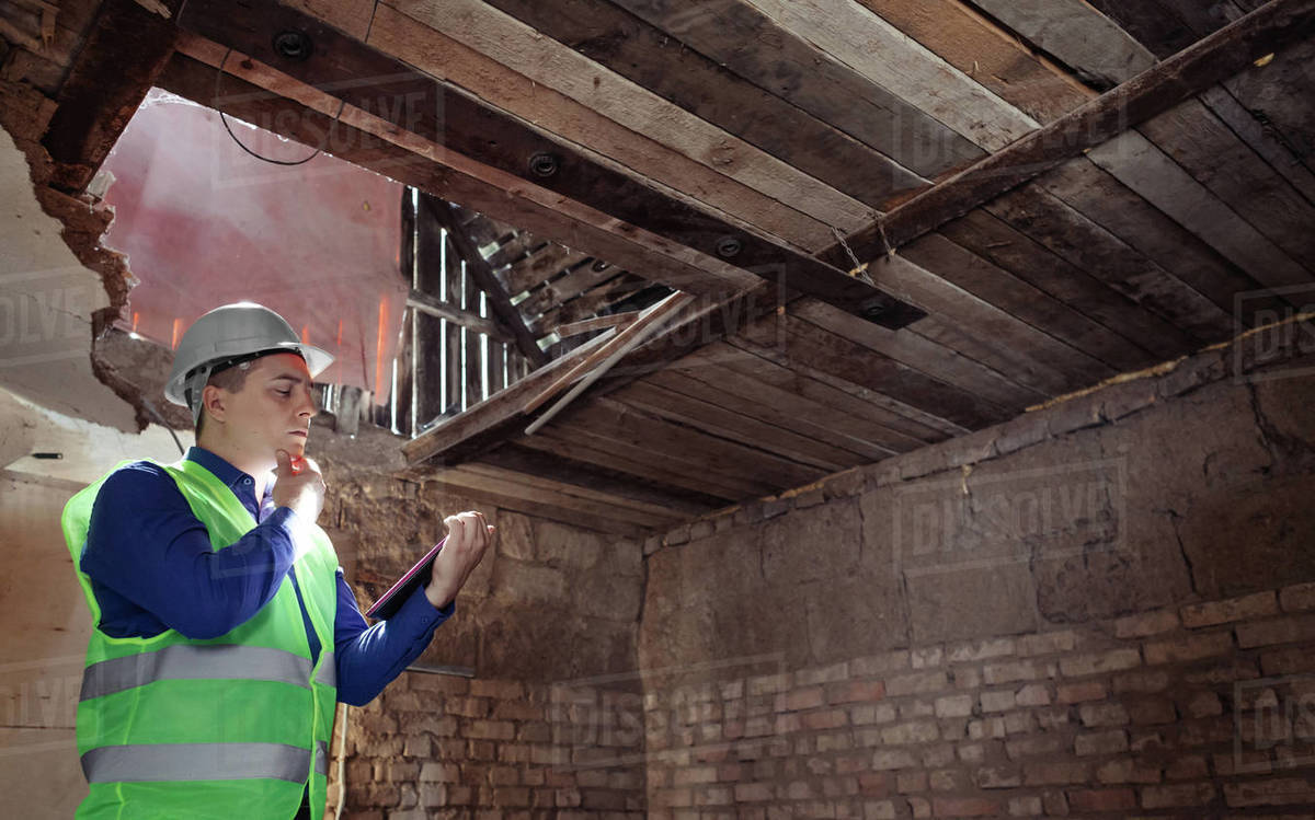 Building inspector. Man in a hard hat and a yellow reflective vest ...