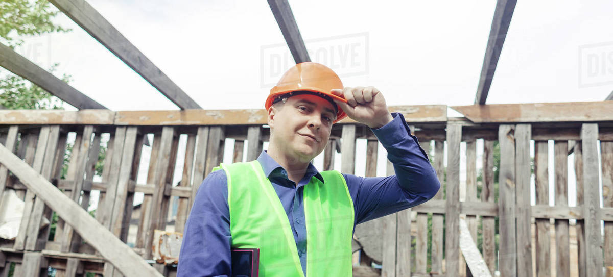 Building inspector. Man in a hard hat and a yellow reflective vest ...