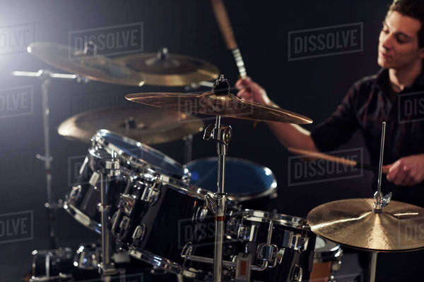 Side view of young drummer playing drum kit in studio - Royalty-free ...