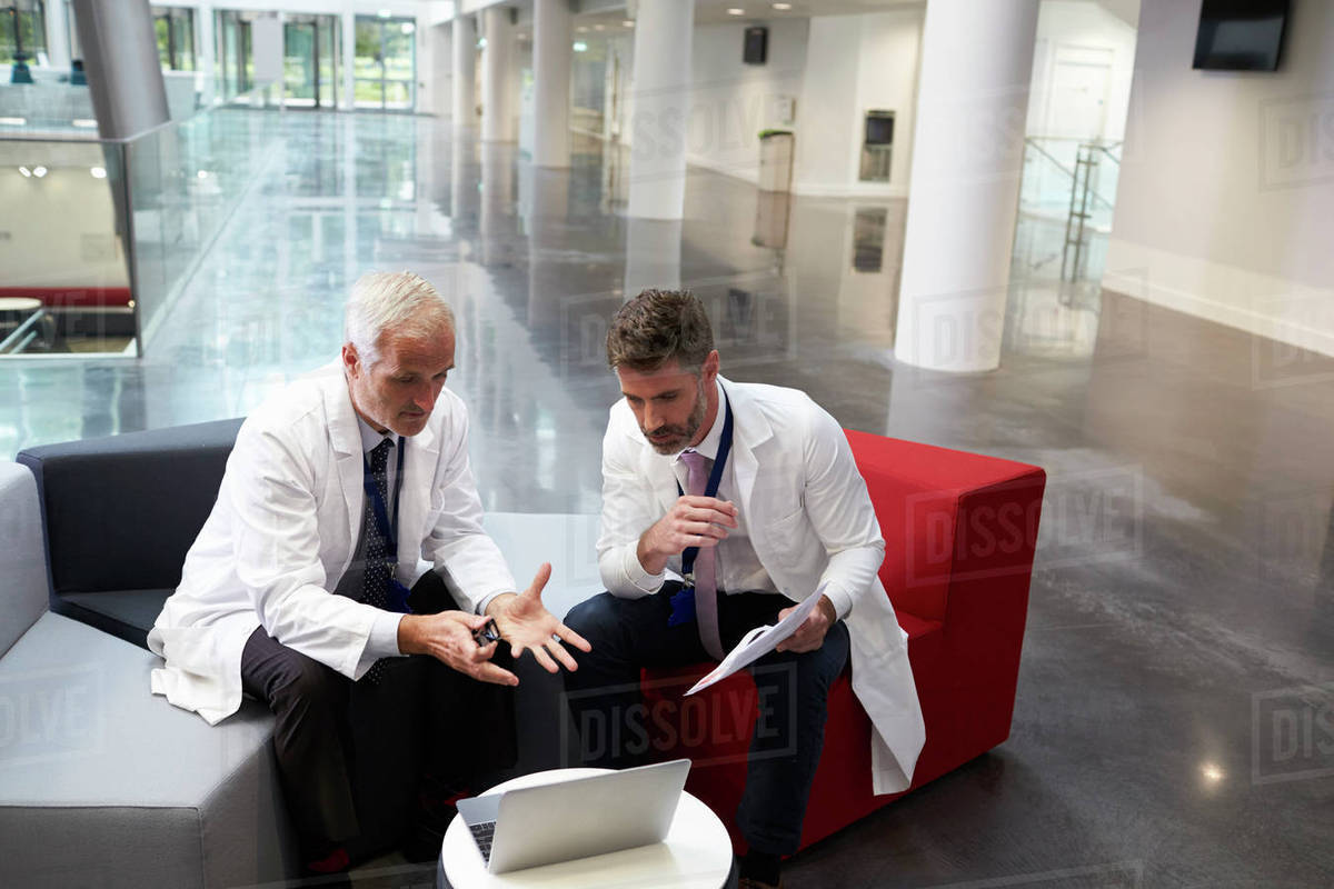 Two doctors having meeting in hospital reception area - Royalty-free ...
