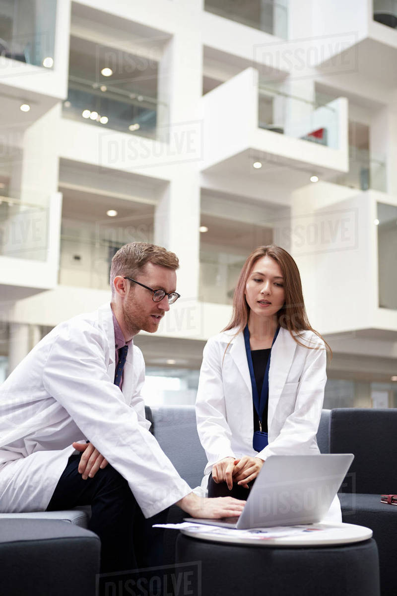 Two doctors having meeting in hospital reception area - Stock Photo ...