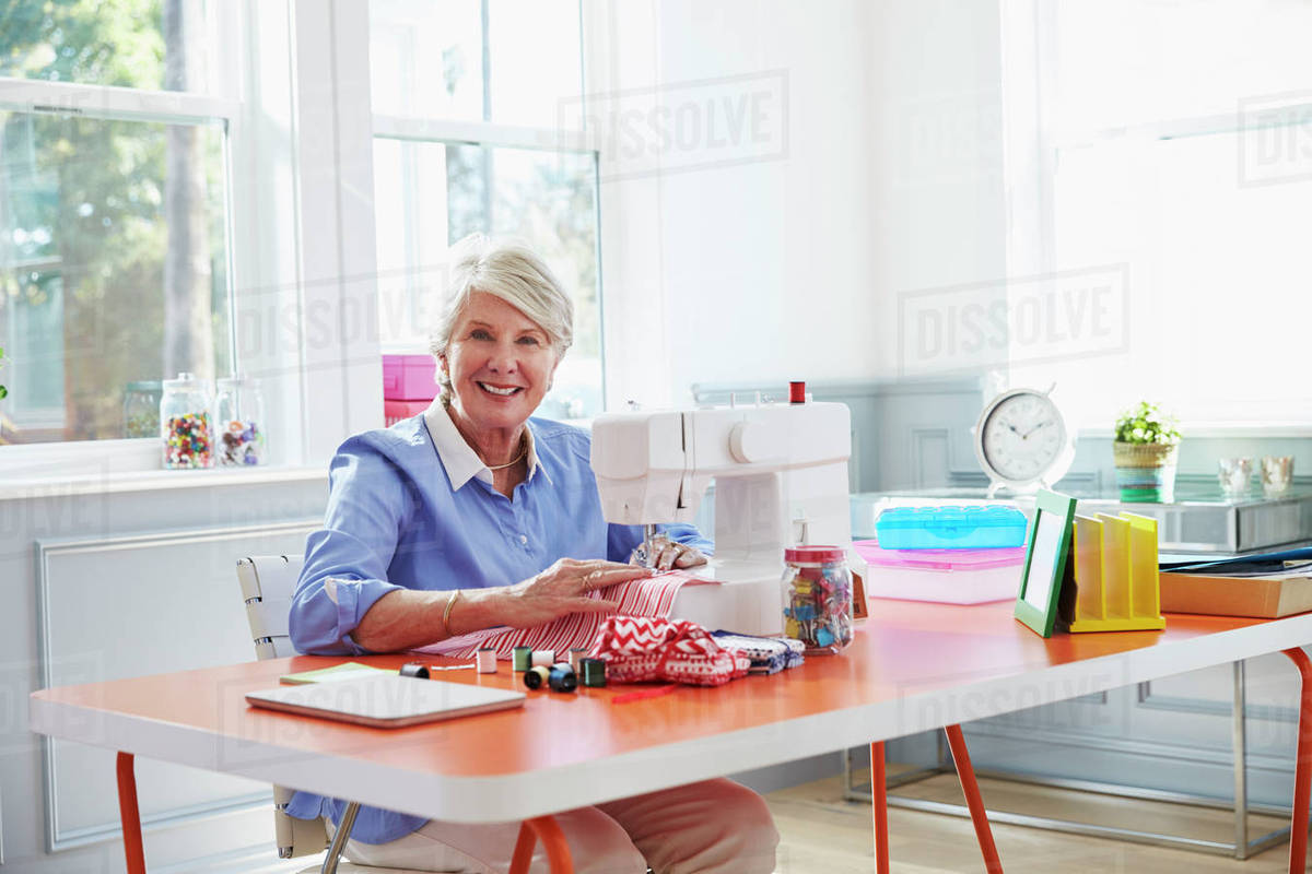 Senior Woman Making Clothes Using Sewing Machine At Home - Royalty-free ...