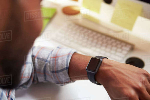 Close-up of businessman wearing smart watch in design office - Stock ...