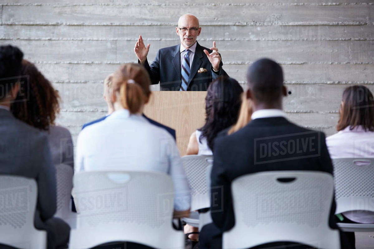 Senior businessman addressing delegates at conference - Stock Photo ...