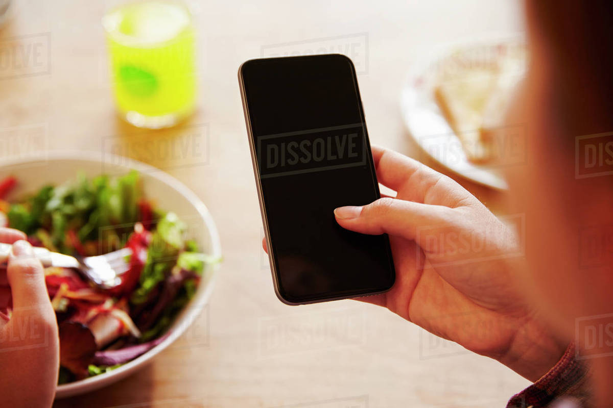Person at lunch looking at to mobile phone - Royalty-free Stock Photo ...
