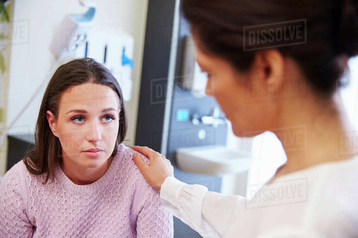 Female patient being reassured by doctor in hospital room - Stock Photo ...