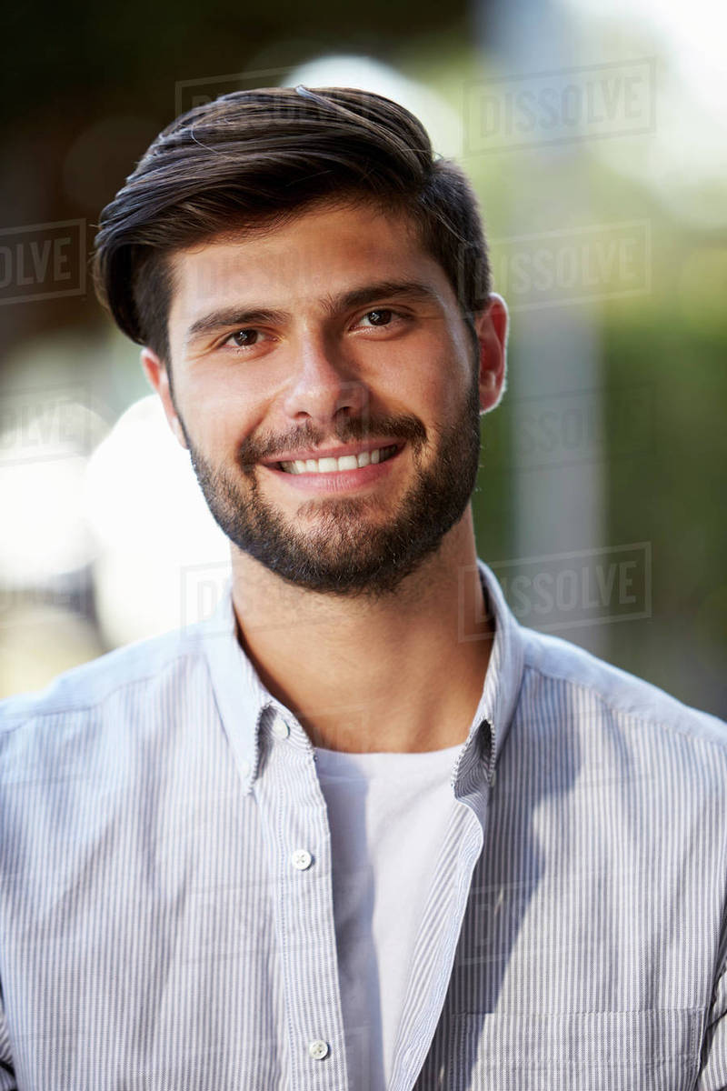 Vertical portrait of bearded young man sitting outside - Royalty-free ...
