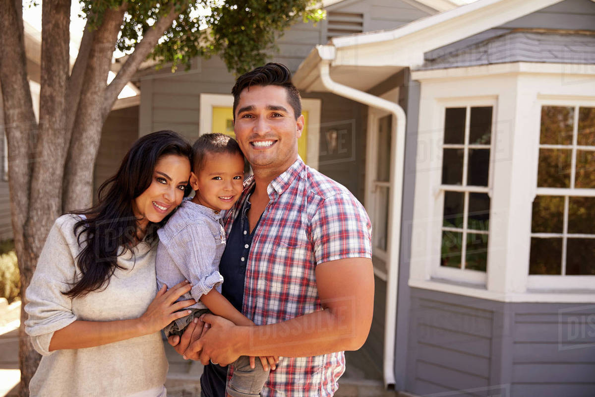 Portrait of family standing outside home - Stock Photo - Dissolve