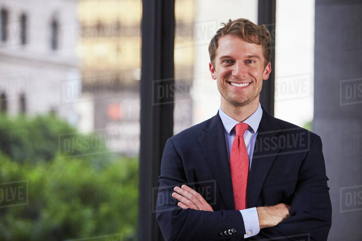 Young white businessman with arms crossed smiling, waist up - Royalty ...