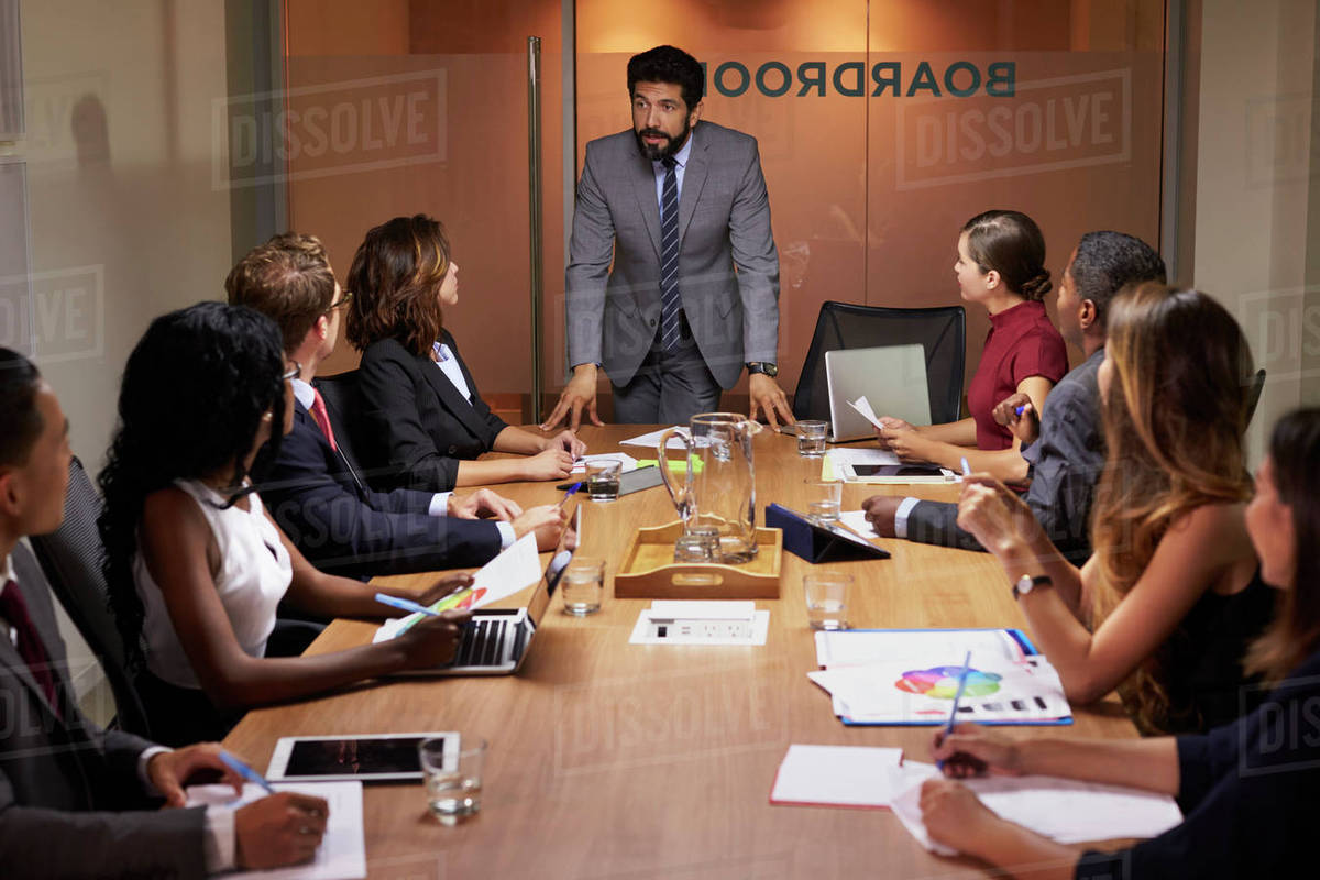 Businessman addressing colleagues at a boardroom meeting - Stock Photo ...