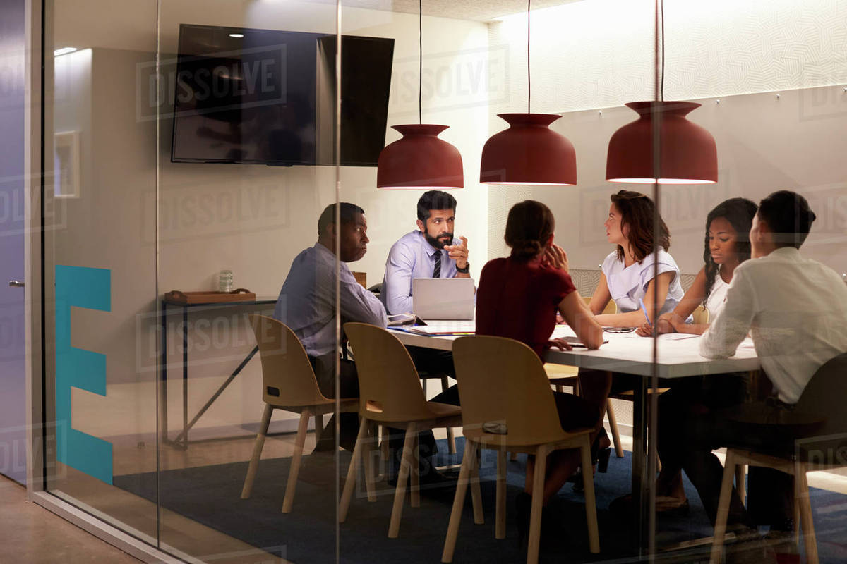 Corporate team at table in a meeting room cubicle, close-up - Stock ...