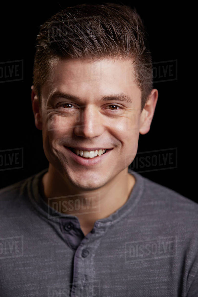 Portrait of a smiling young white man looking to camera, vertical ...