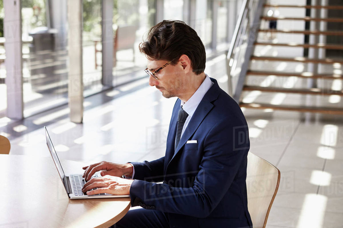 Young professional man using laptop, elevated view - Royalty-free Stock ...