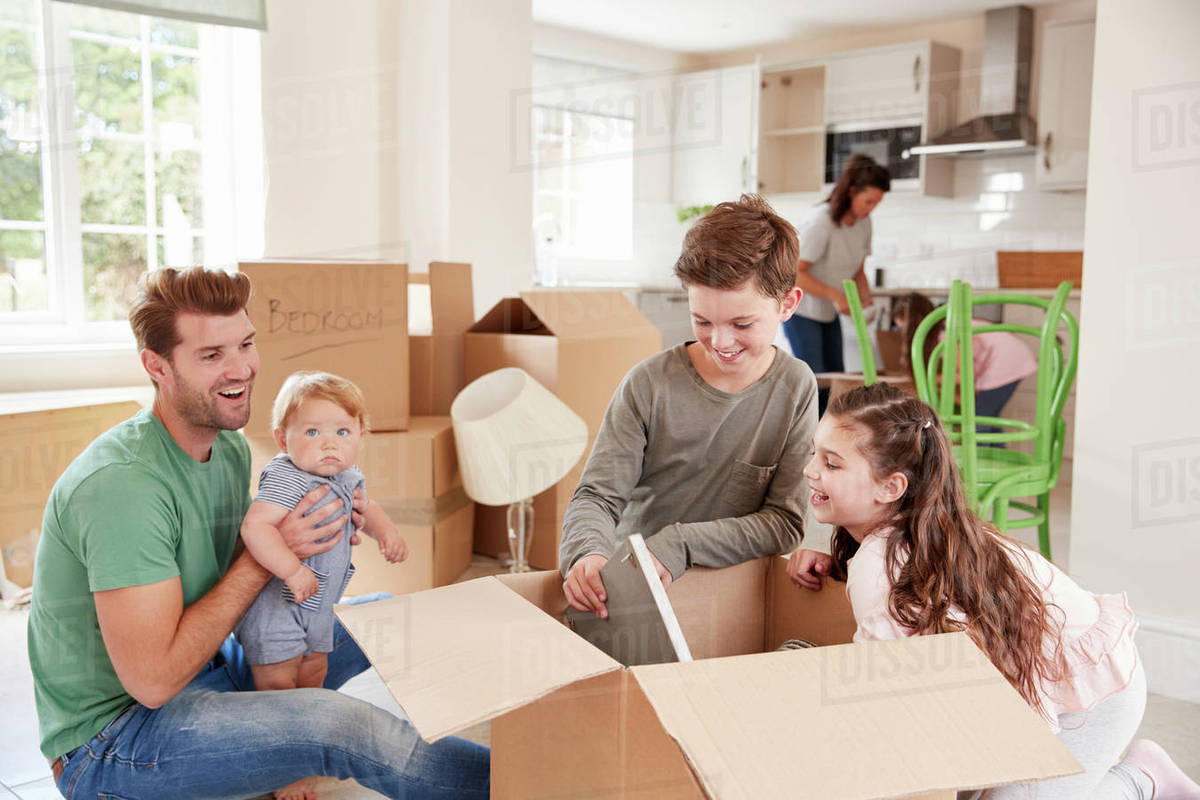 Children Helping Parents To Unpack On Moving In Day - Royalty-free ...