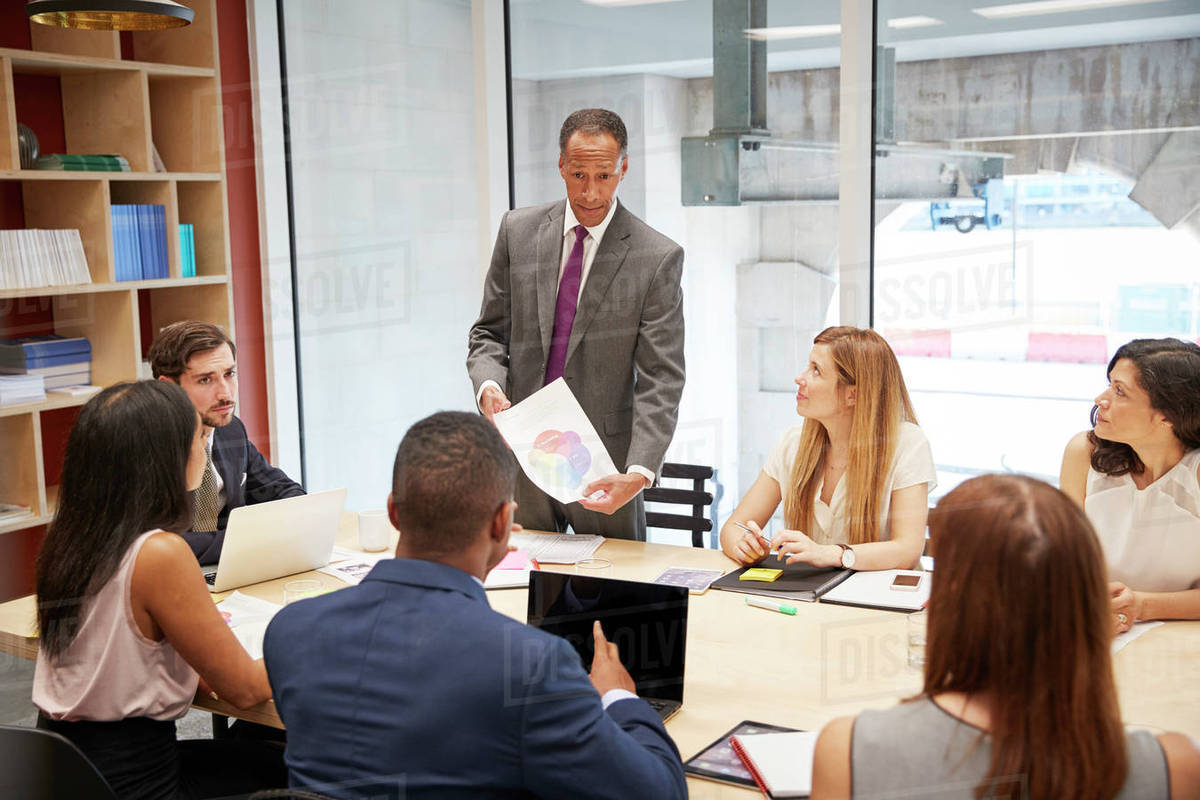 Male boss holding document at a business boardroom meeting - Royalty ...