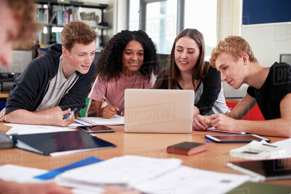 Group Of College Students Collaborating On Project In Library Stock 